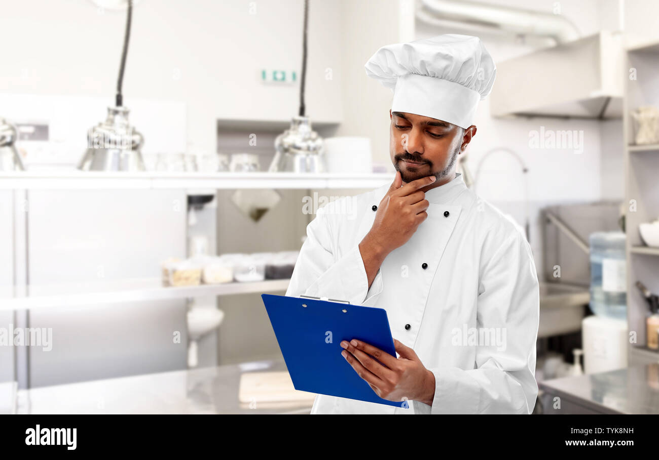 indian chef with clipboard at restaurant kitchen Stock Photo - Alamy