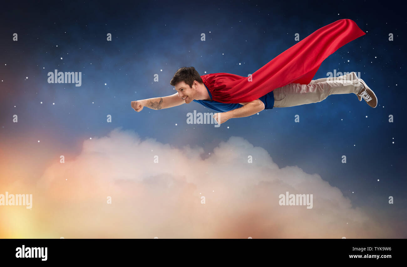 man in red superhero cape flying over night sky Stock Photo - Alamy