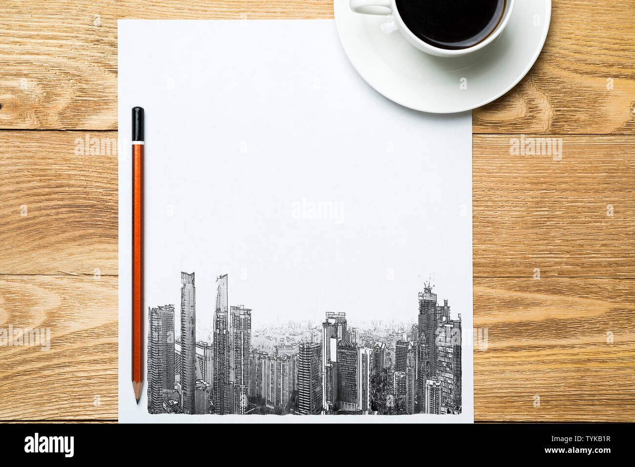 Wooden table with coffee cup and architectural sketches on notepad ...