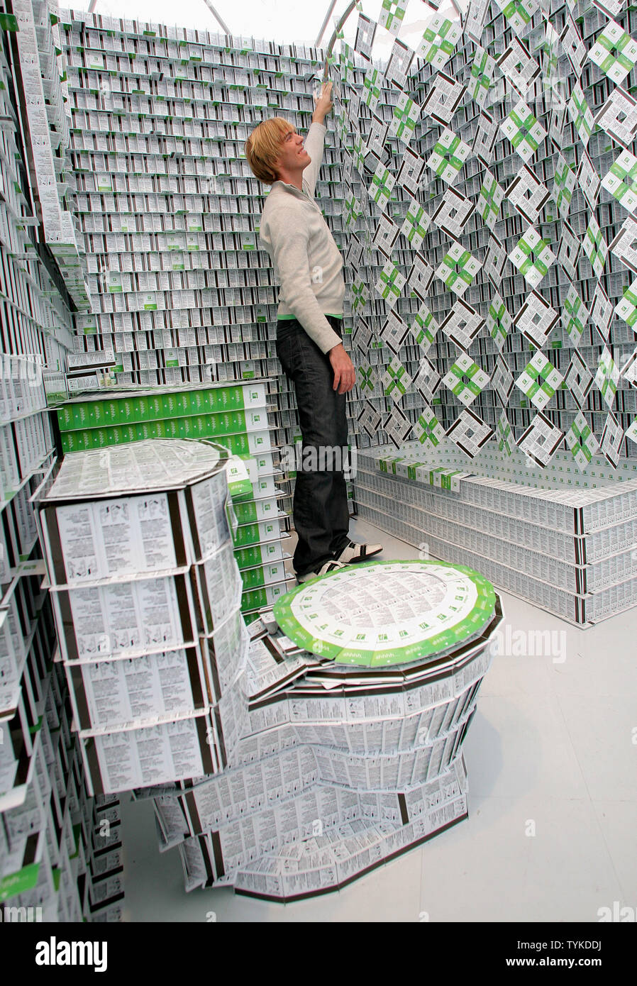 Bryan Berg, a world-record card stacker, pulls back a shower curtain ...