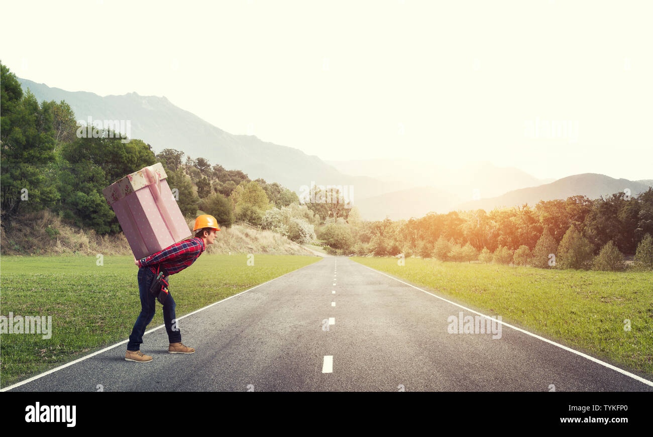 Man carrying on his back large box Stock Photo - Alamy