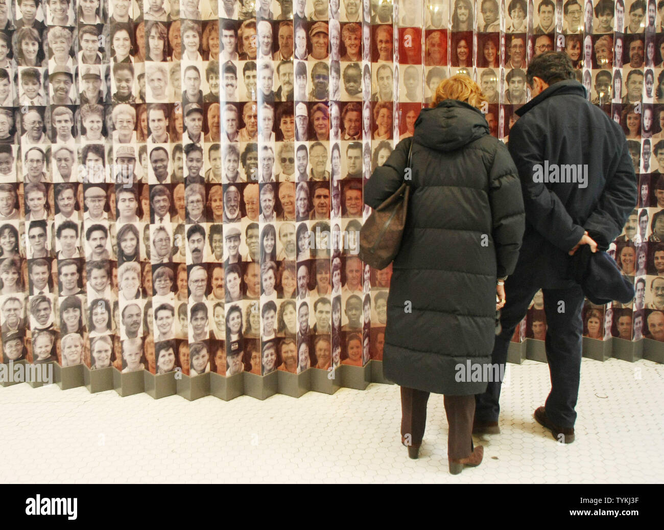 Visitors look at the wall of immigrants' portraits in the Ellis Island ...