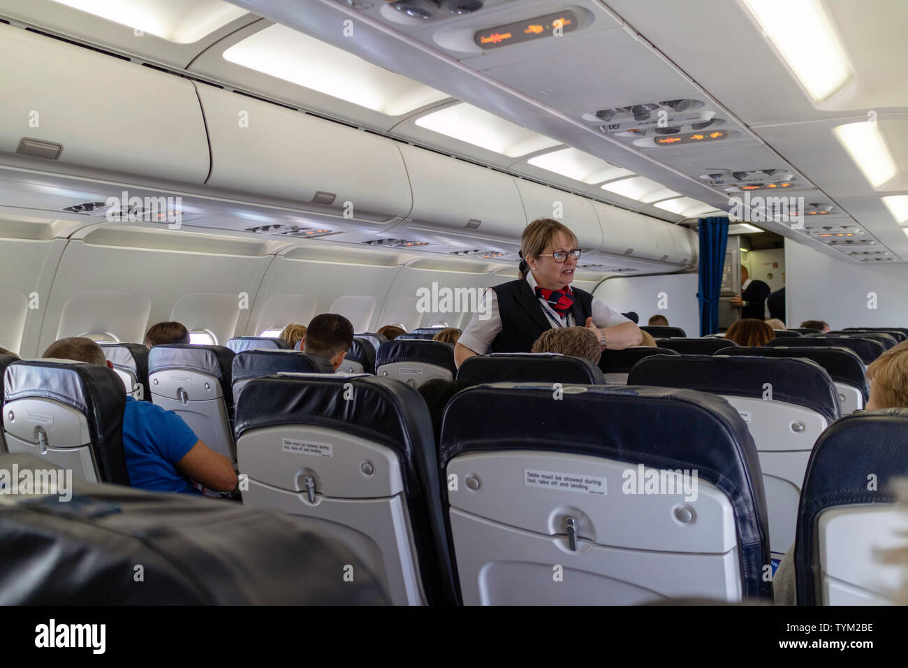 Inflight service on a passenger jet with crew member speaking to a ...