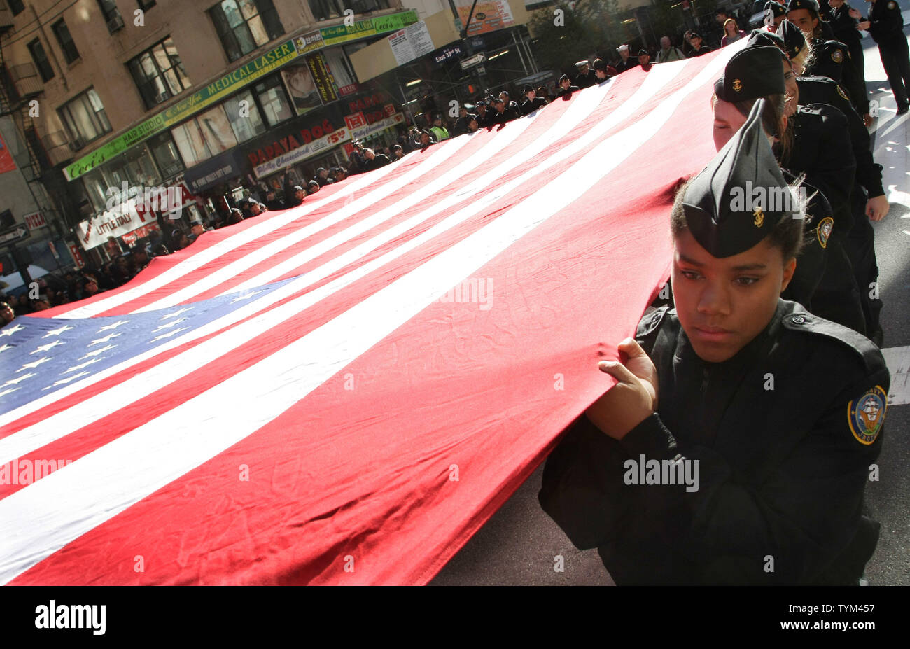 Members of the ROTC carry a giant American Flag along Fifth Avenue ...