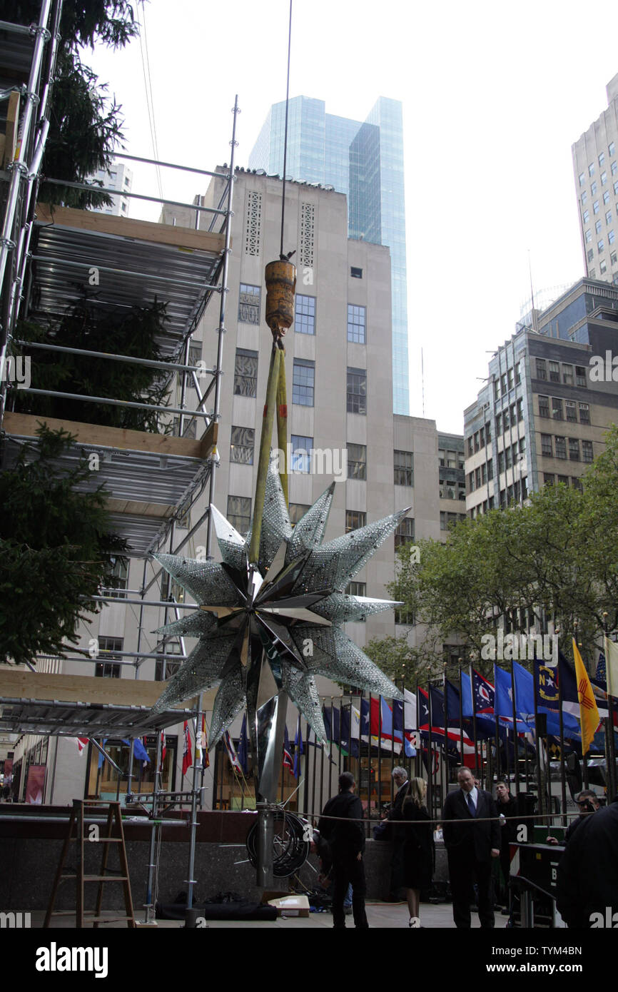 The Swarovski star is lifted up in the air to be placed on the ...