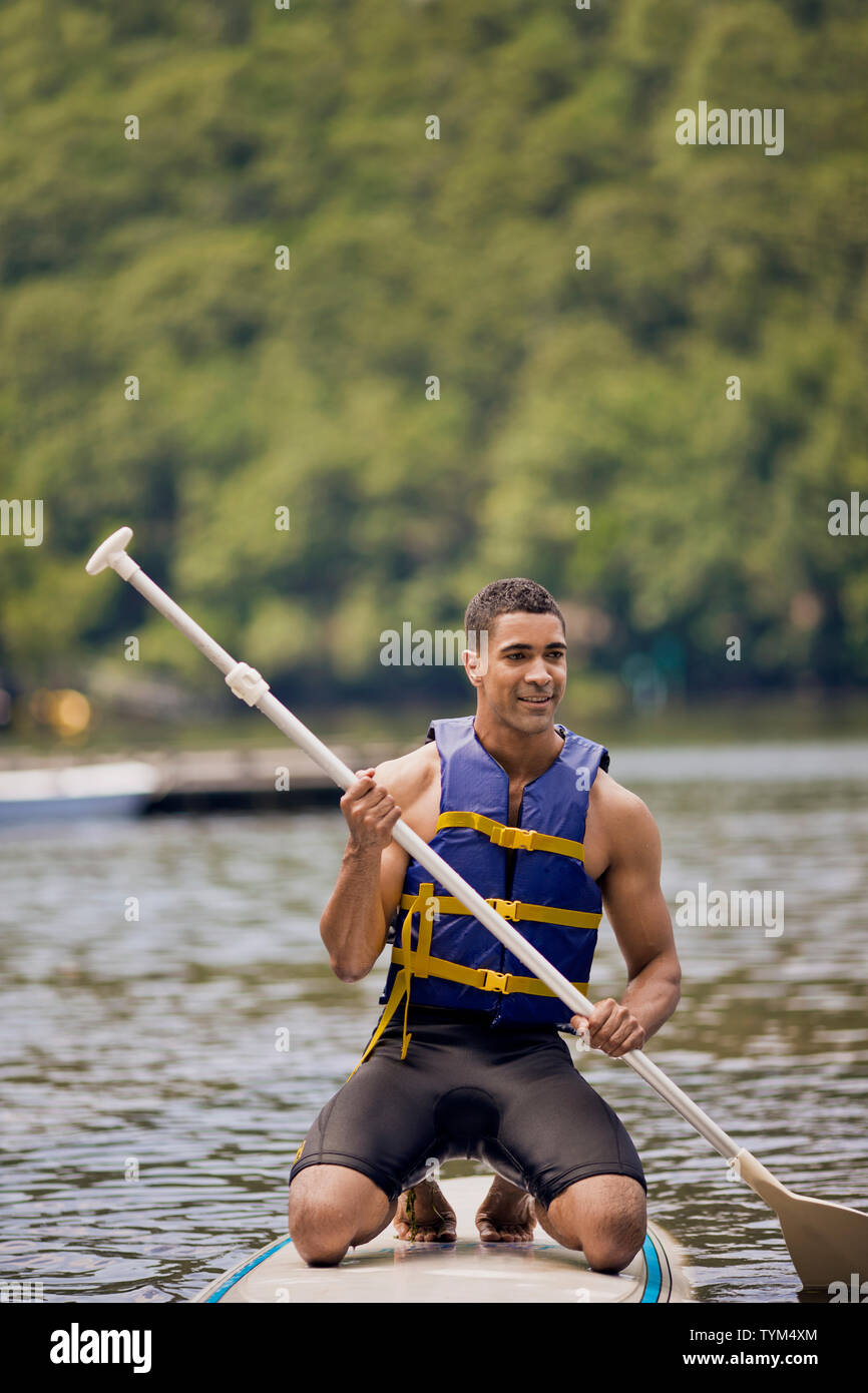 Young man paddle boarding hi-res stock photography and images - Alamy