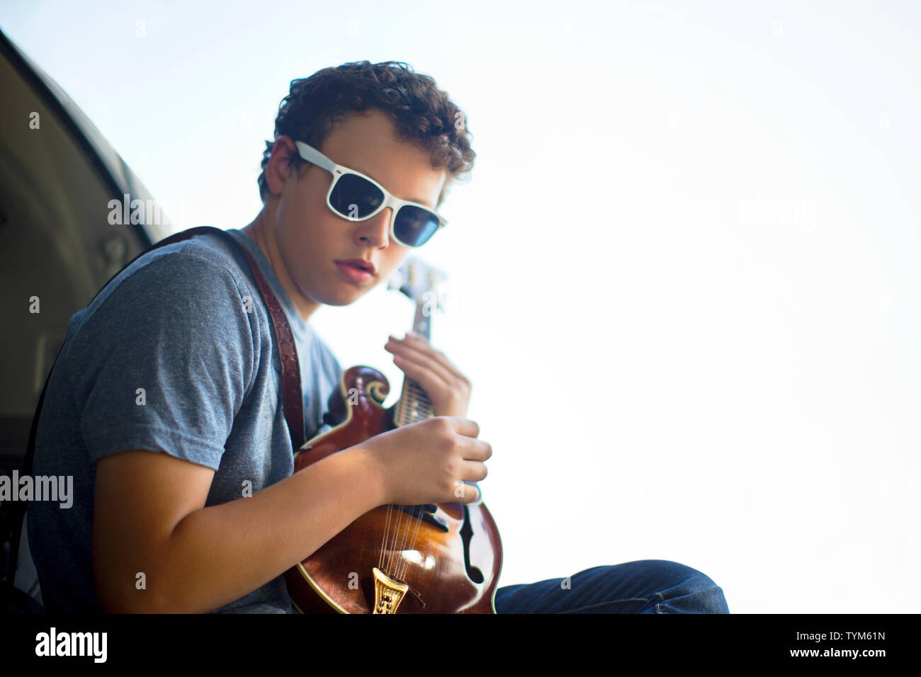 Teenage boy playing a mandolin Stock Photo - Alamy