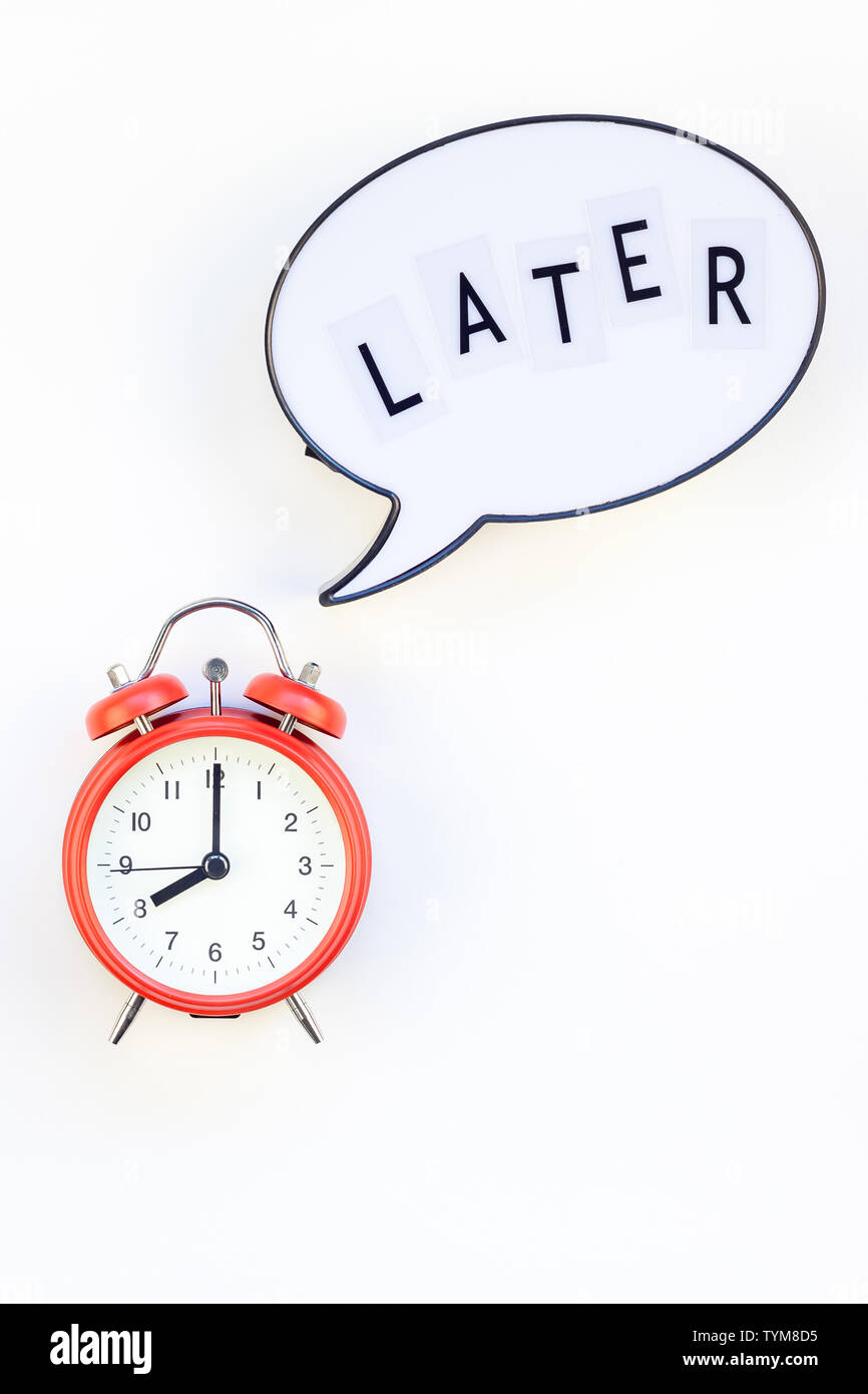 Creative top view flat lay of alarm clock with message Later copy space ...