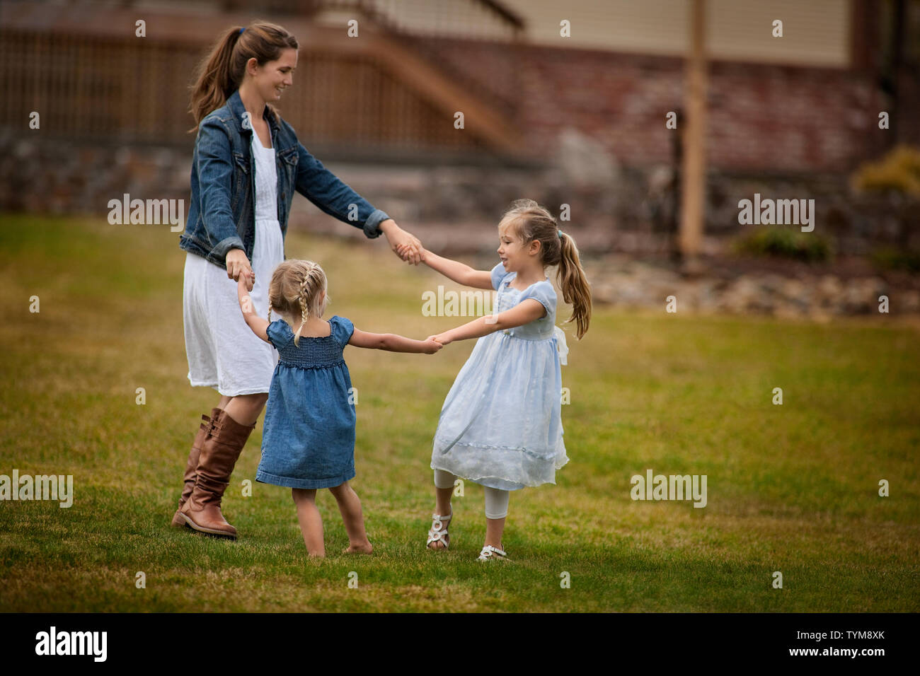 Two little girls have fun playing ring-around-the-rosie with their ...