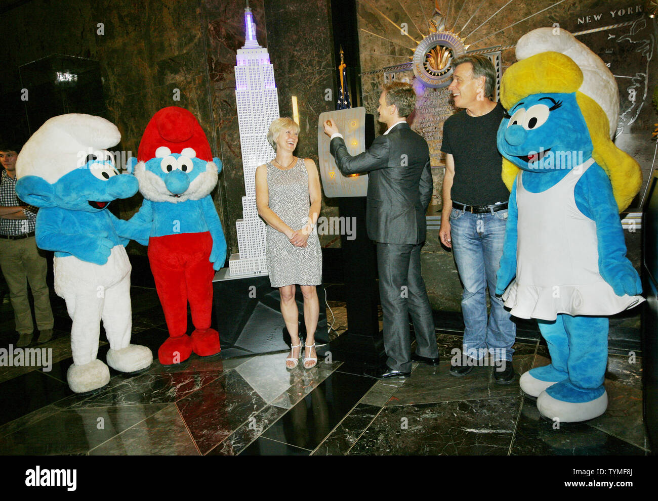 Neil Patrick Harris, center, throws a switch which lights a model of ...