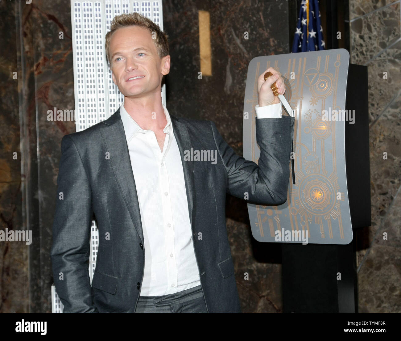 Neil Patrick Harris throws a switch which lights a model of the Empire ...