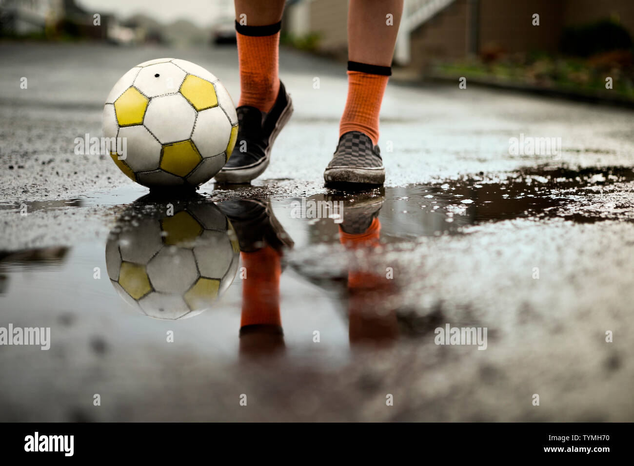Boy playing with soccer ball in street Stock Photo - Alamy