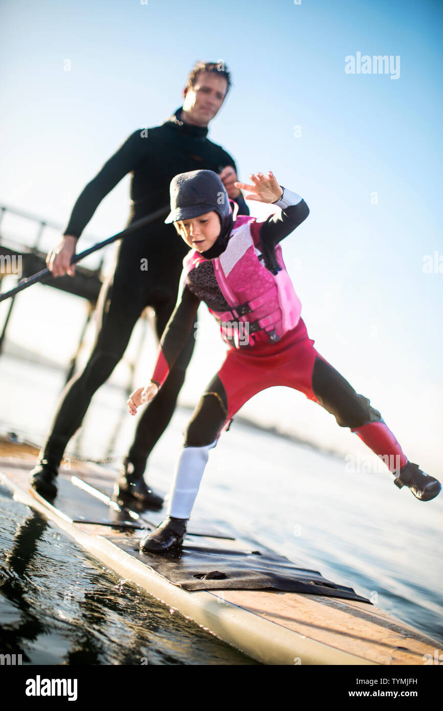 Father and daughter paddleboarding together Stock Photo - Alamy