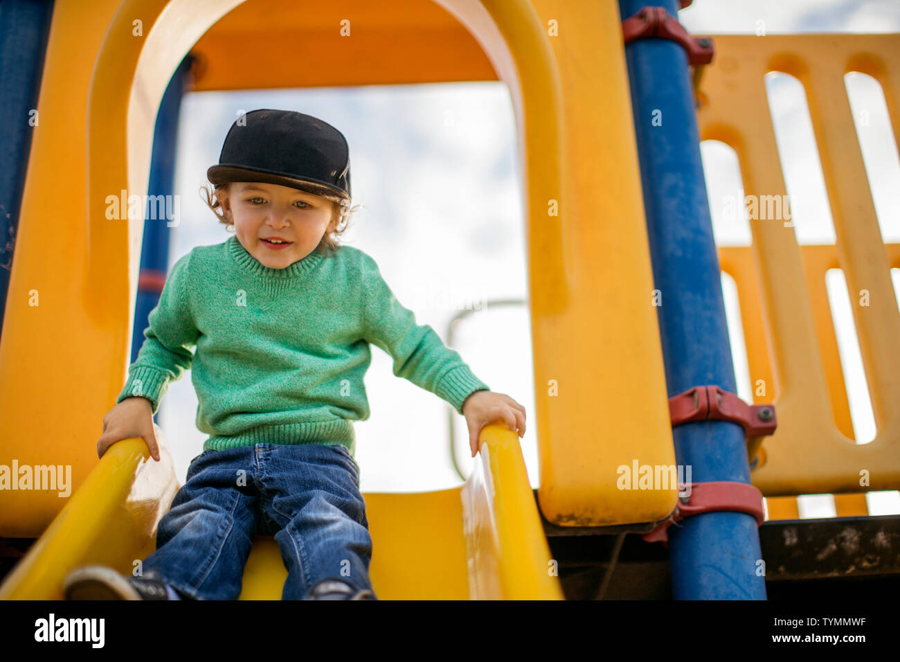 Young boy playing on slide Stock Photo - Alamy