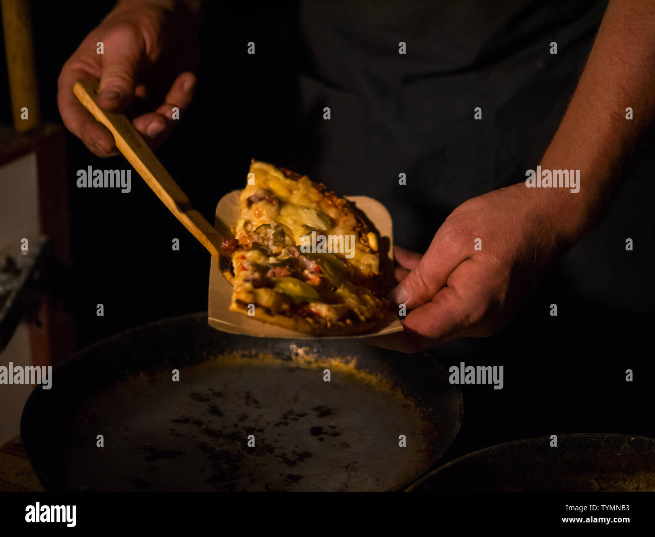 Man picking up pizza slice Stock Photo - Alamy