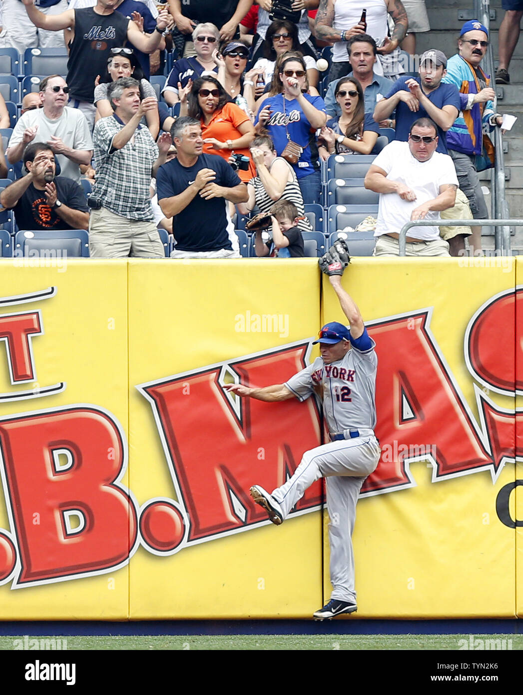 Fans watch New York Mets Scott Hairston leap to catch a ball hit by New ...