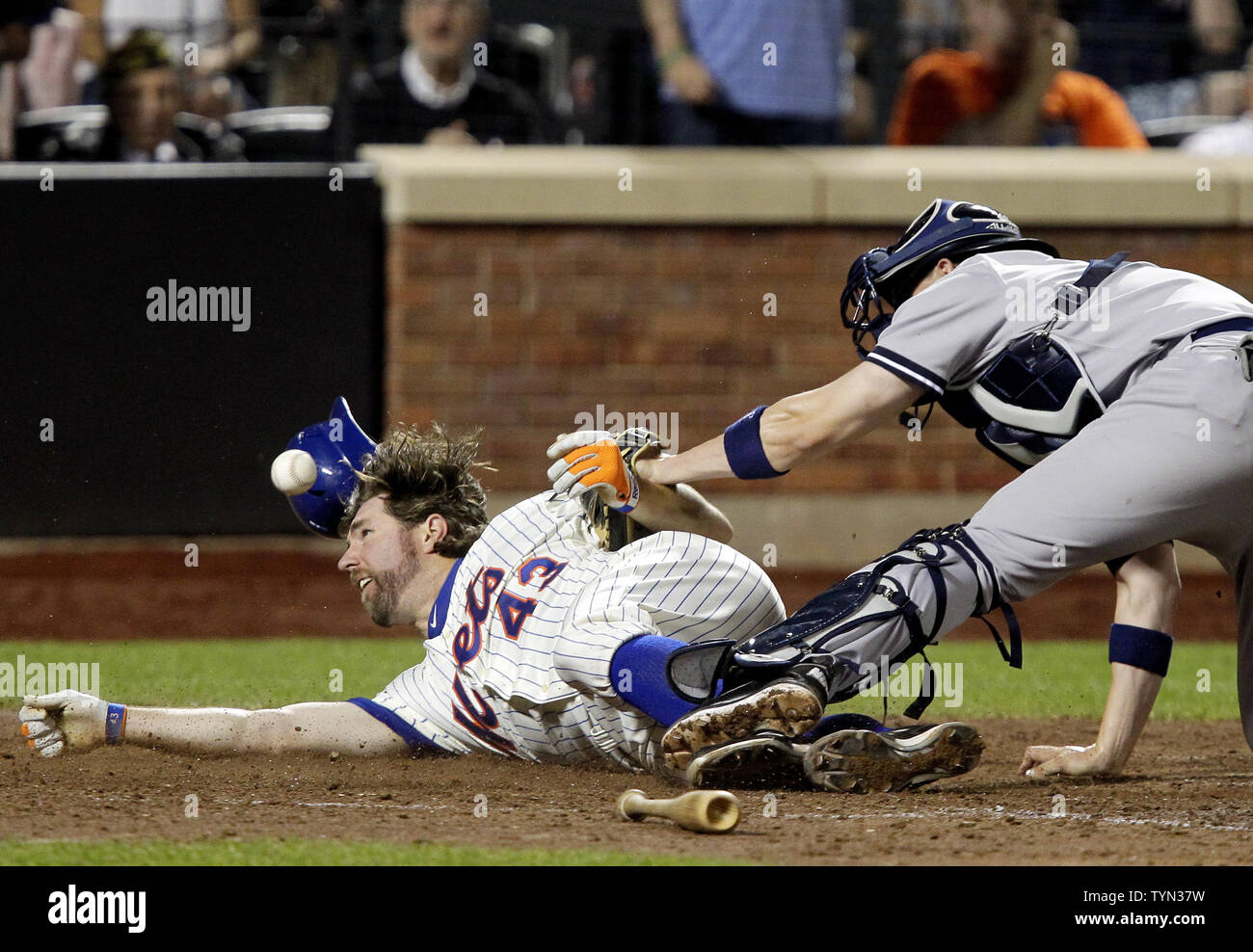 New York Mets starting pitcher R.A. Dickey scores a run sliding into ...