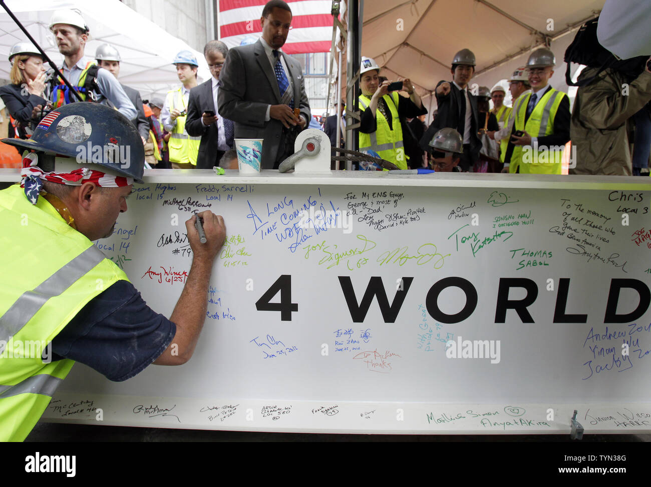 Construction workers sign the final steel beam before it is raised by ...