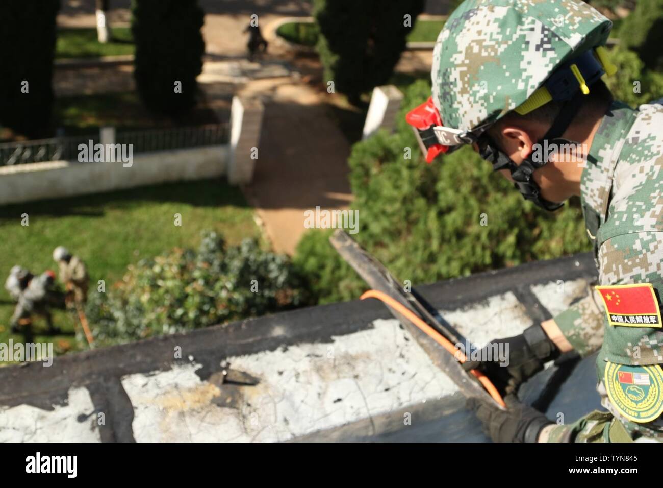 A People’s Liberation Army soldier secures roping attached to a rooftop ...