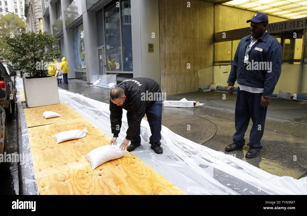 Men try to protect a Con Edison vault from flooding with sand bags ...