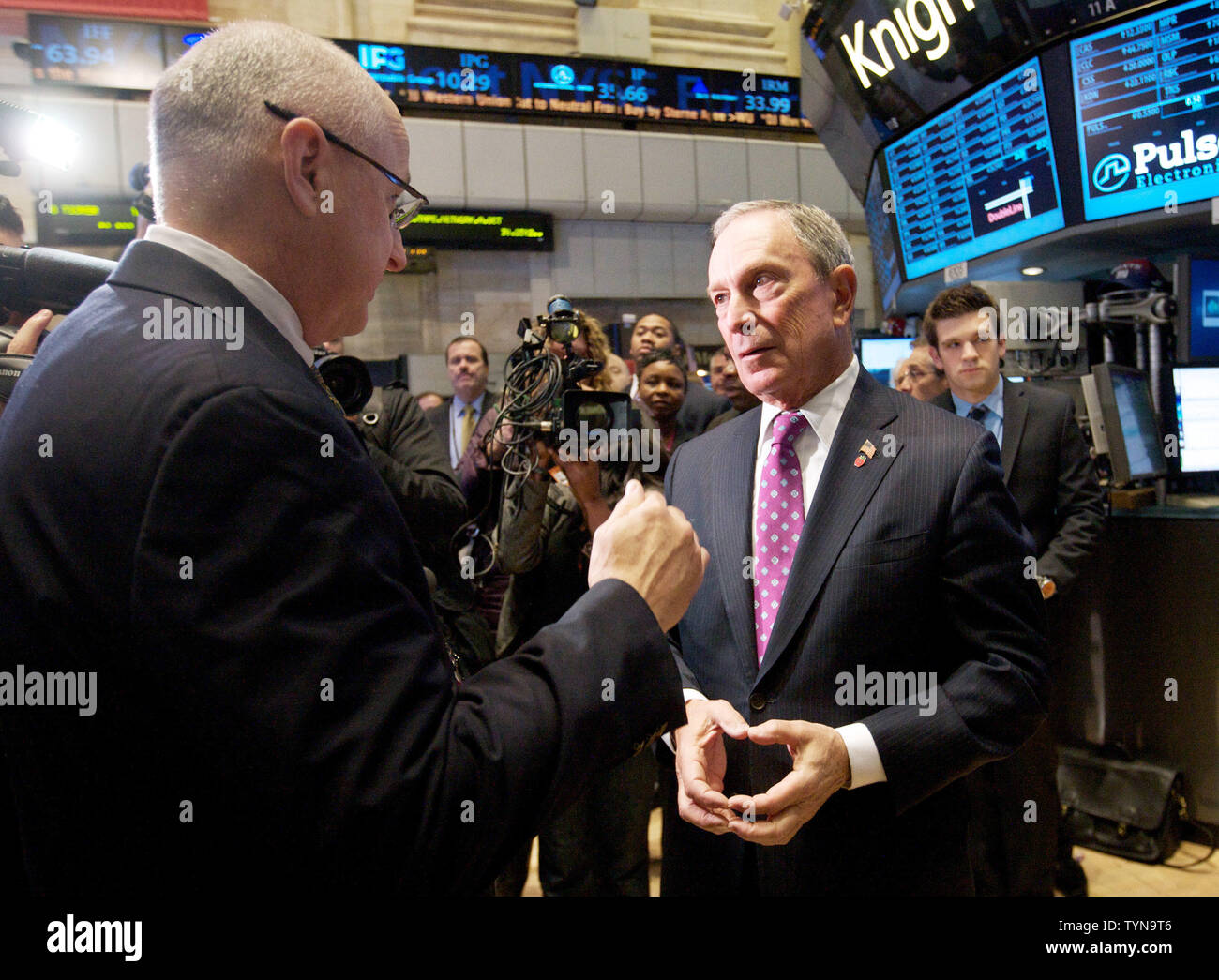 New York City Mayor Michael Bloomberg (R) talks with a trader as the ...