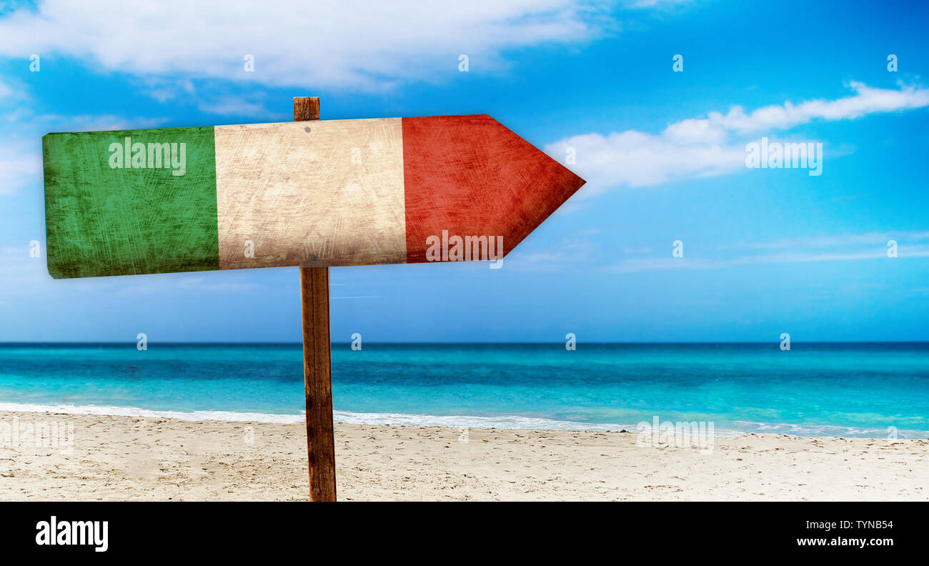 Italy flag on wooden table sign on beach background. There is beach and ...