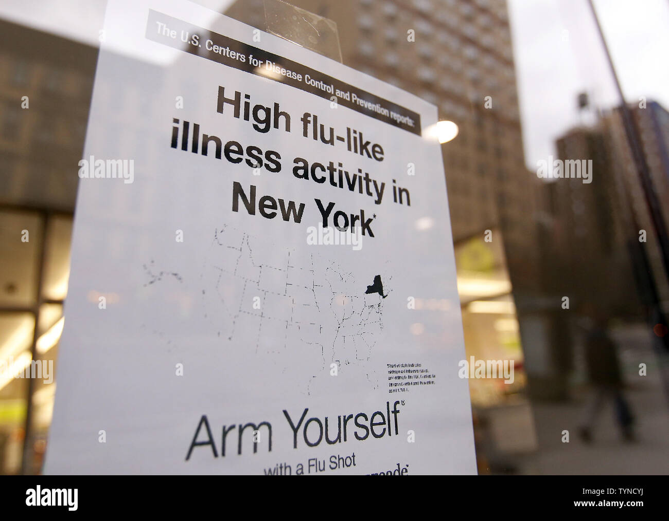 A flu illness warning sign is taped to a window at a pharmacy in New ...