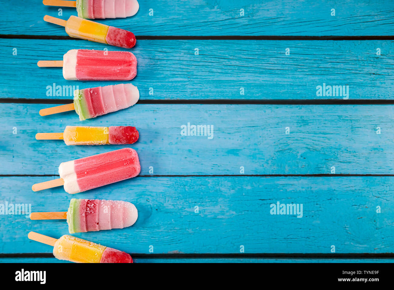 Colorful fruit ice cream stick look fresh to eat placed on a blue ...