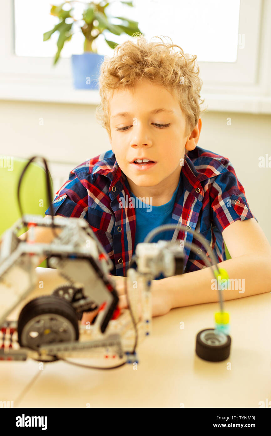 Studying robotics. Pleasant intelligent boy studying robotics while ...