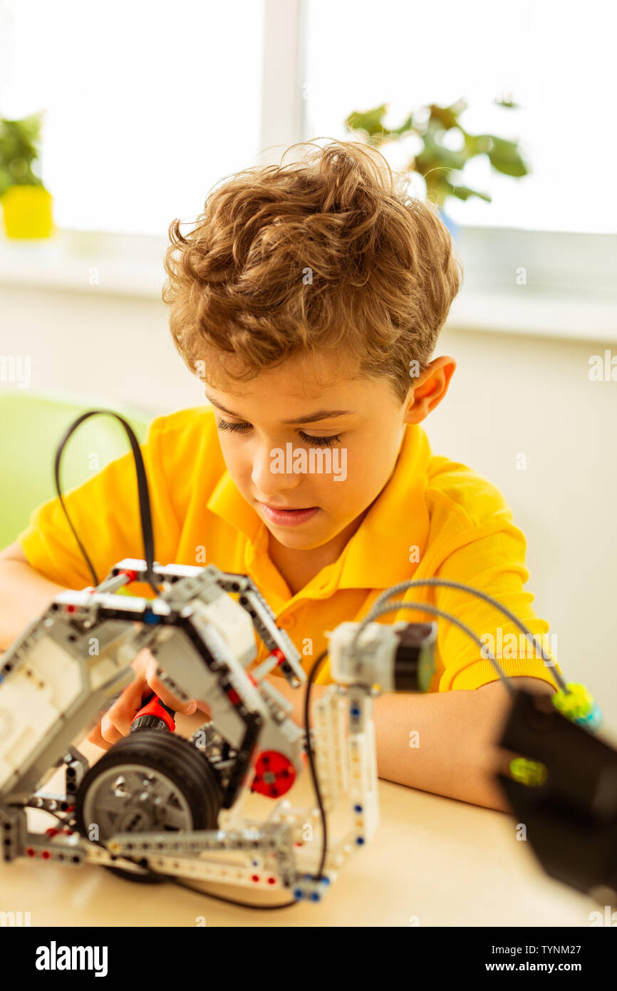 Young genius. Nice young boy constructing a robot while being very good ...