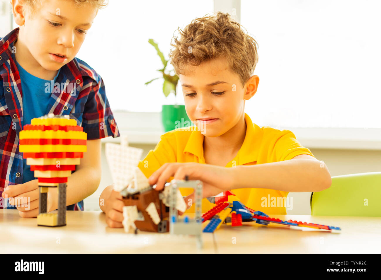 Developing skills. Delighted cheerful boy playing with a constructor ...