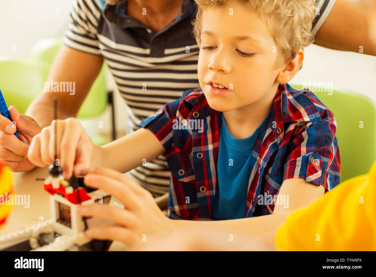 My hobby. Cute engaged boy focusing on the toy construction while ...