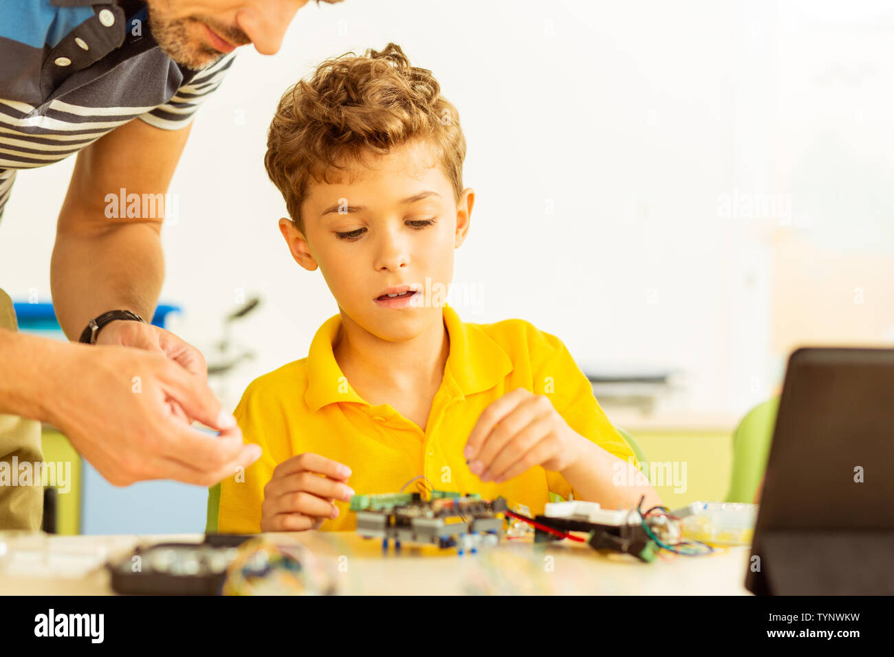 Modern education. Intelligent smart boy sitting in the classroom while ...