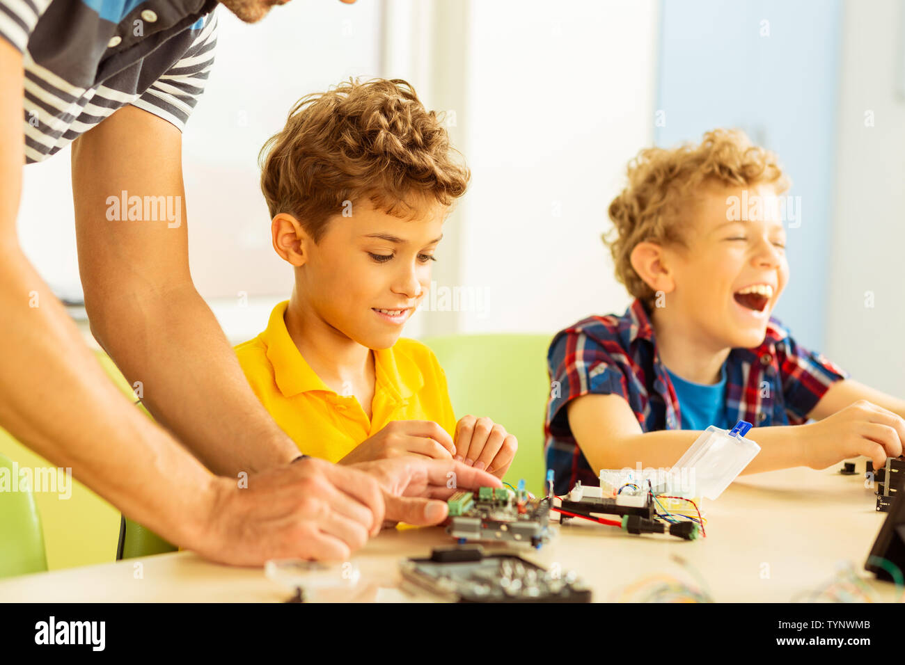 Successful project. Positive nice boy smiling while doing his project ...