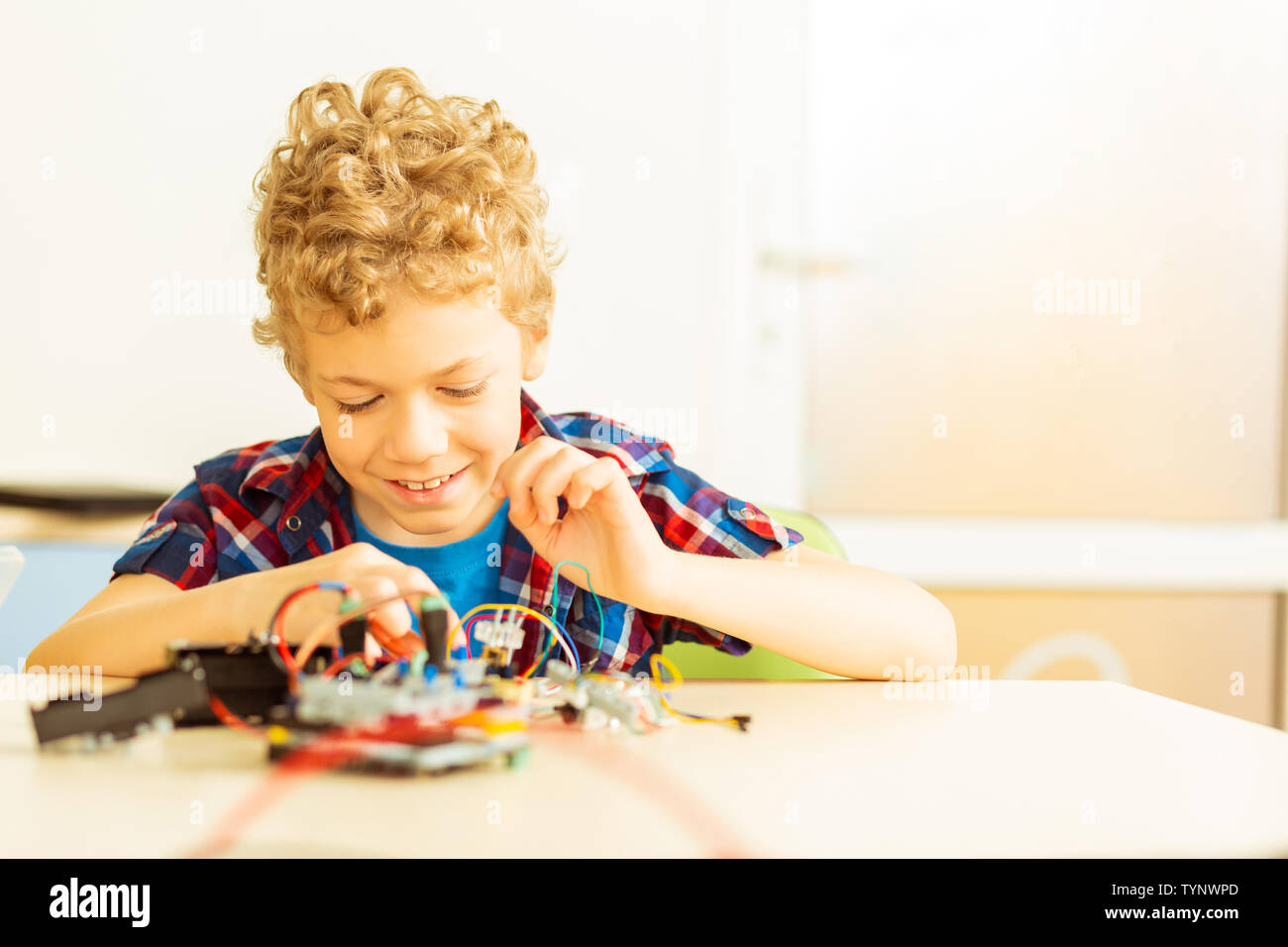 Future robot. Happy cute boy looking at the electronic details while ...