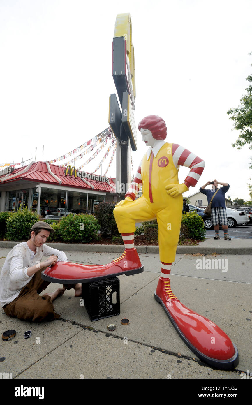 A fiberglass replica of Ronald McDonald having his shoes shined by a ...