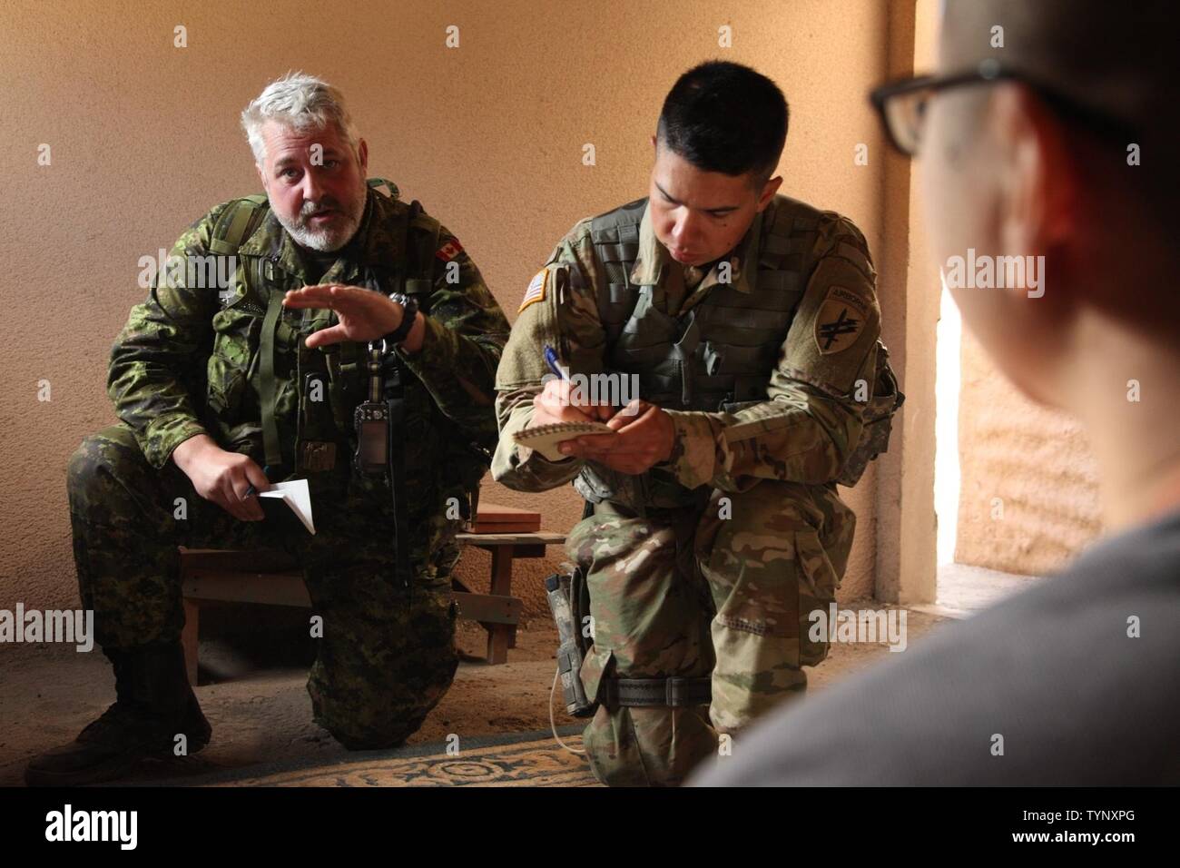 U.S. Army and Canadian Soldiers conduct an interview with a villager in ...