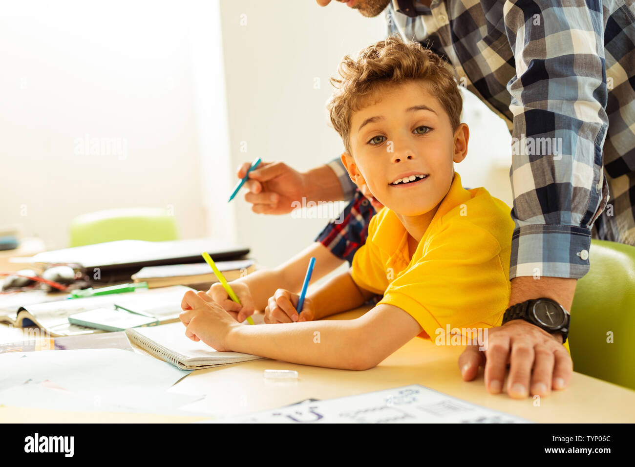Love to knowledge. Happy positive boy smiling to you while enjoying his ...