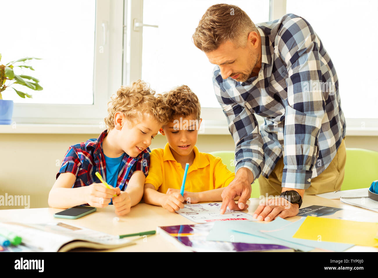 Explaining rules. Nice smart teacher pointing with his finger while ...