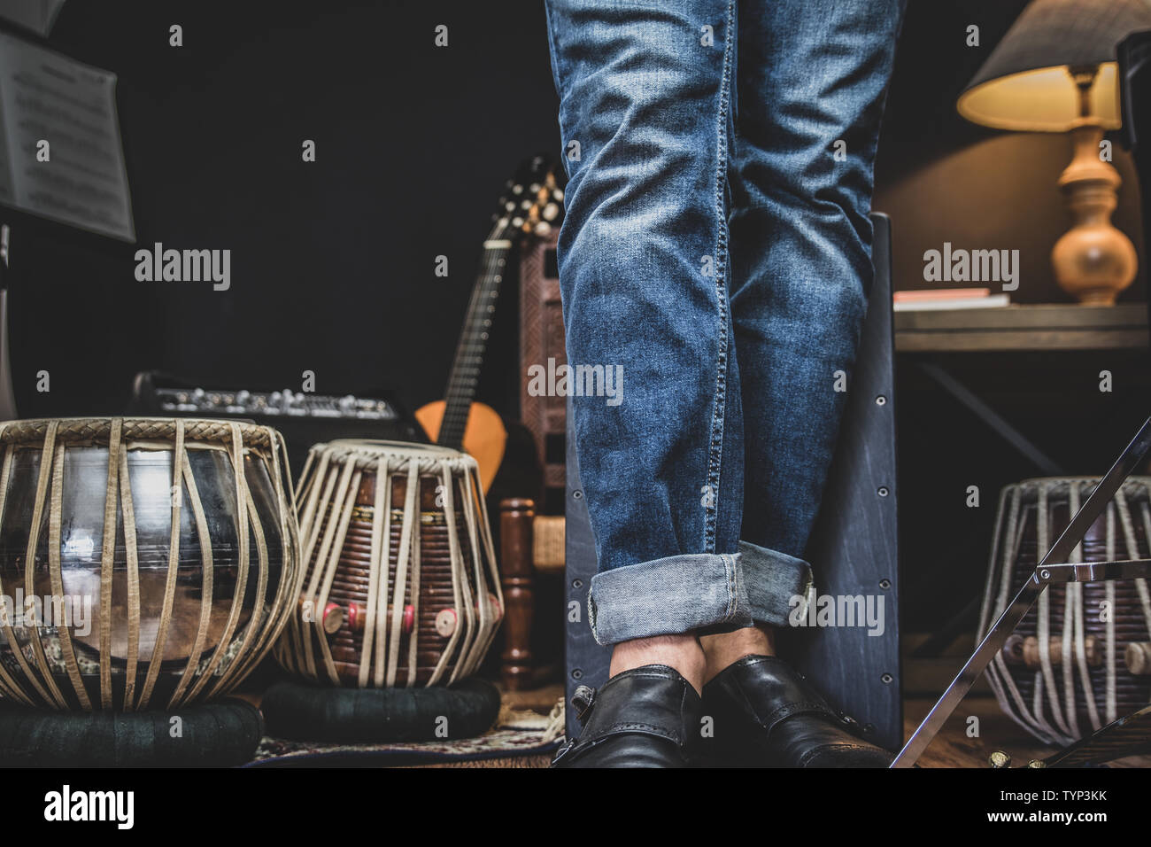 Man in double monk shoes playing the Peruvian percussion instrument ...