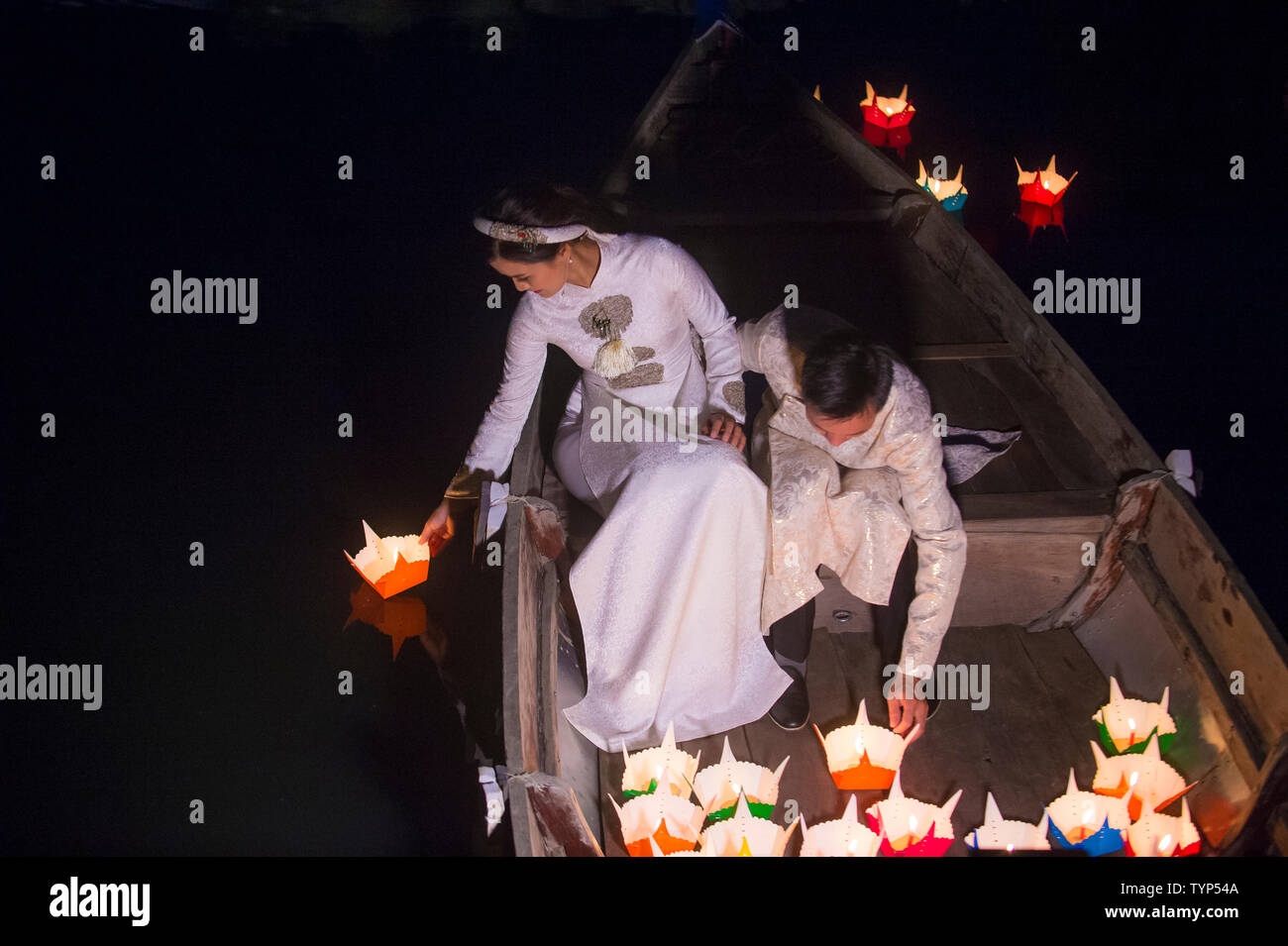 Vietnamese couple dropping lanterns into the river in Hoi An , Vietnam ...