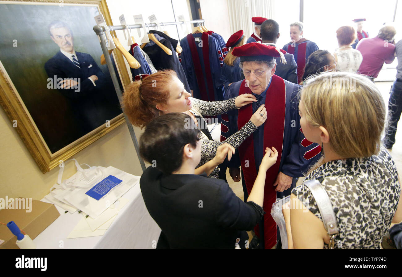 Composer Philip Glass puts on a cap and gown before receiving an ...
