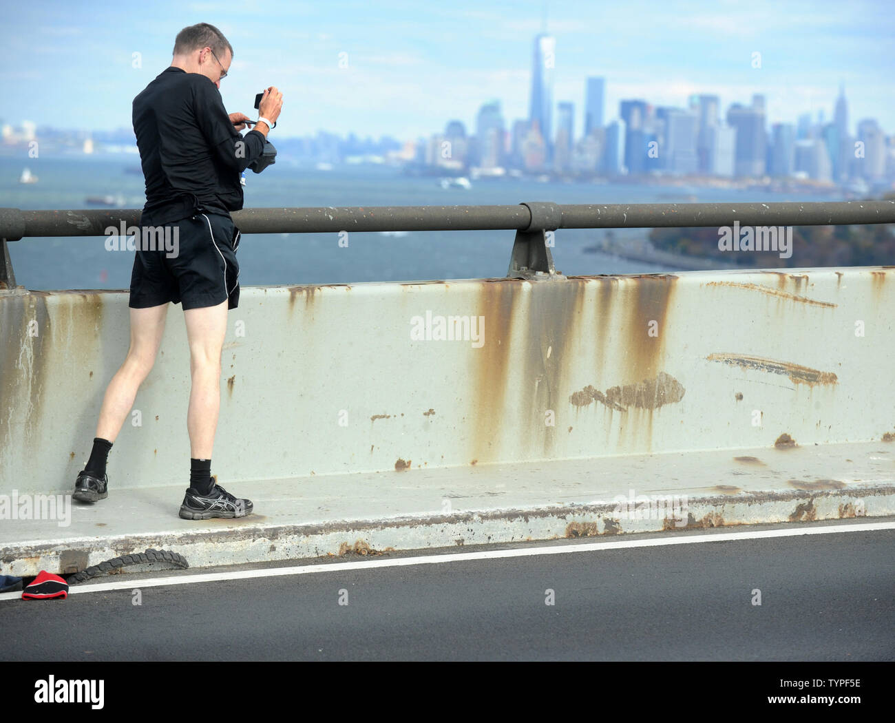 A runner stops to take a photo of the Manhattan skyline and One World ...