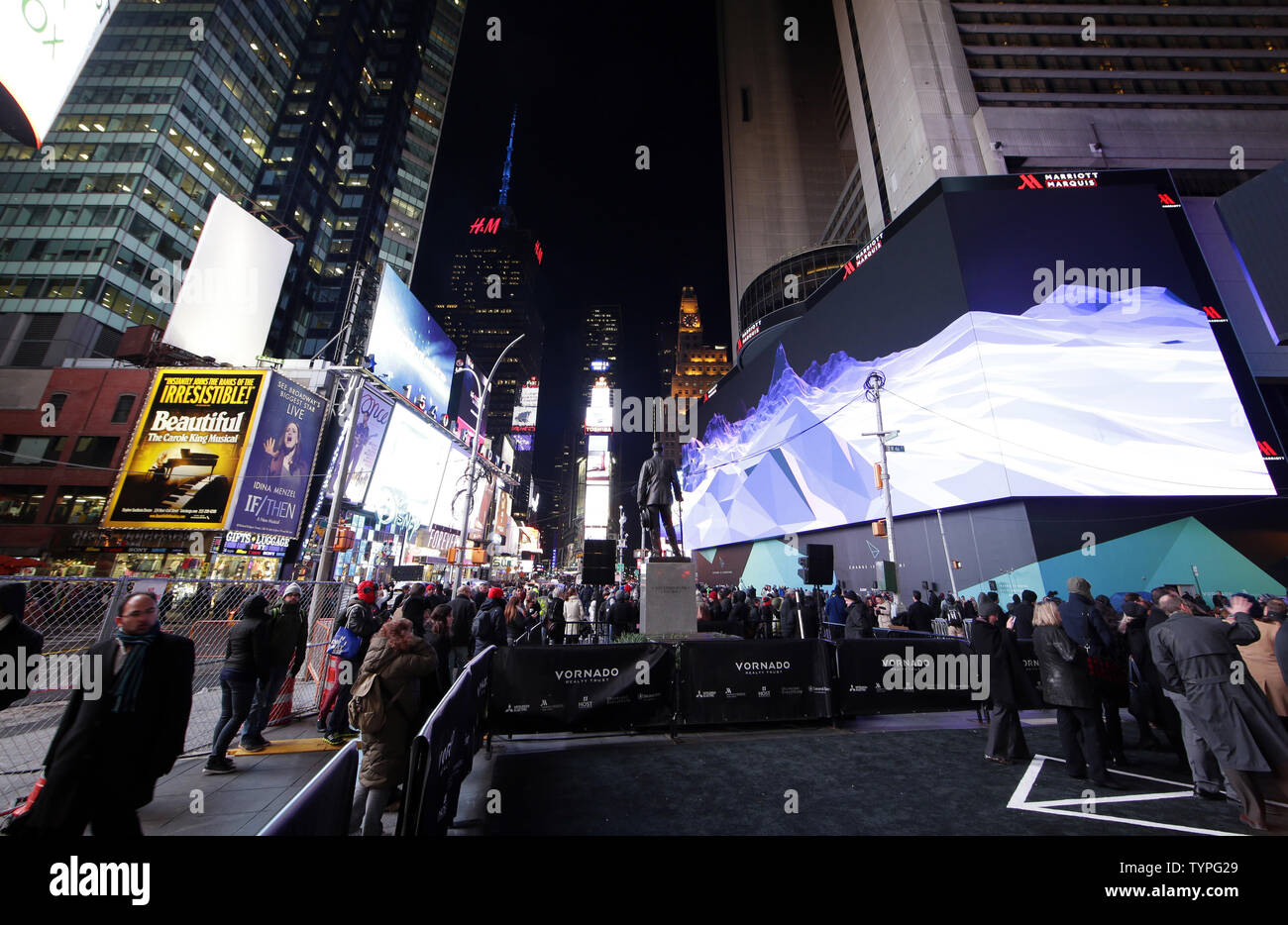 People look up at a giant new billboard that hangs below the Marriott ...