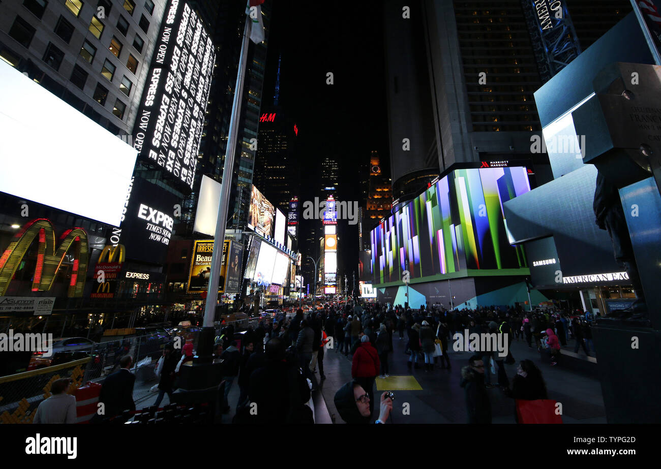 People look up at a giant new billboard that hangs below the Marriott ...