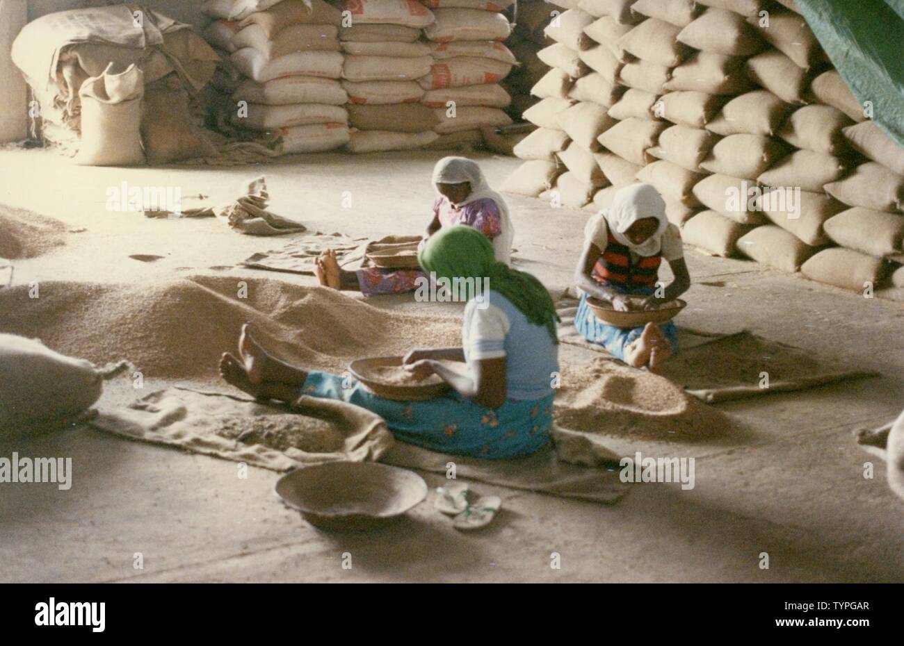 WOMEN SITING DOWN; GRATING SAND BY HAND Stock Photo - Alamy