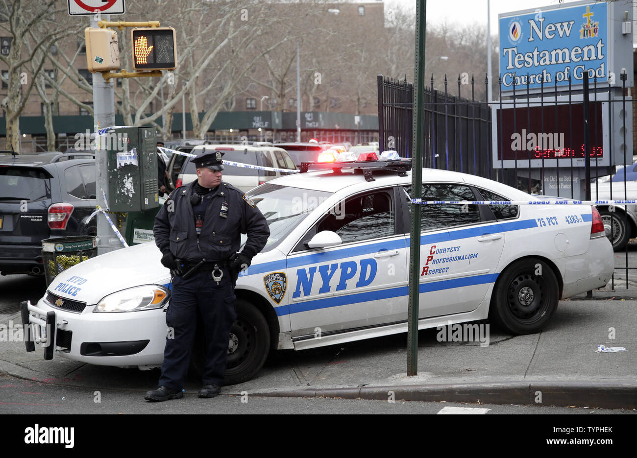 An NYPD Police officer stands guard near police tape that remains up ...