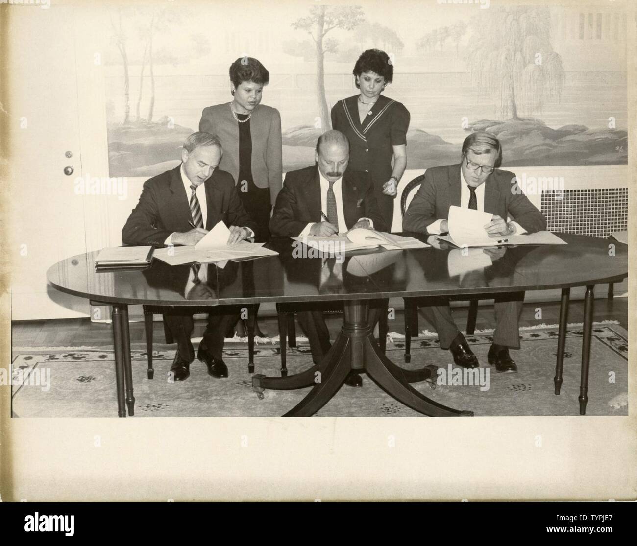 MEN AT A TABLE SIGNING PAPERS Stock Photo - Alamy