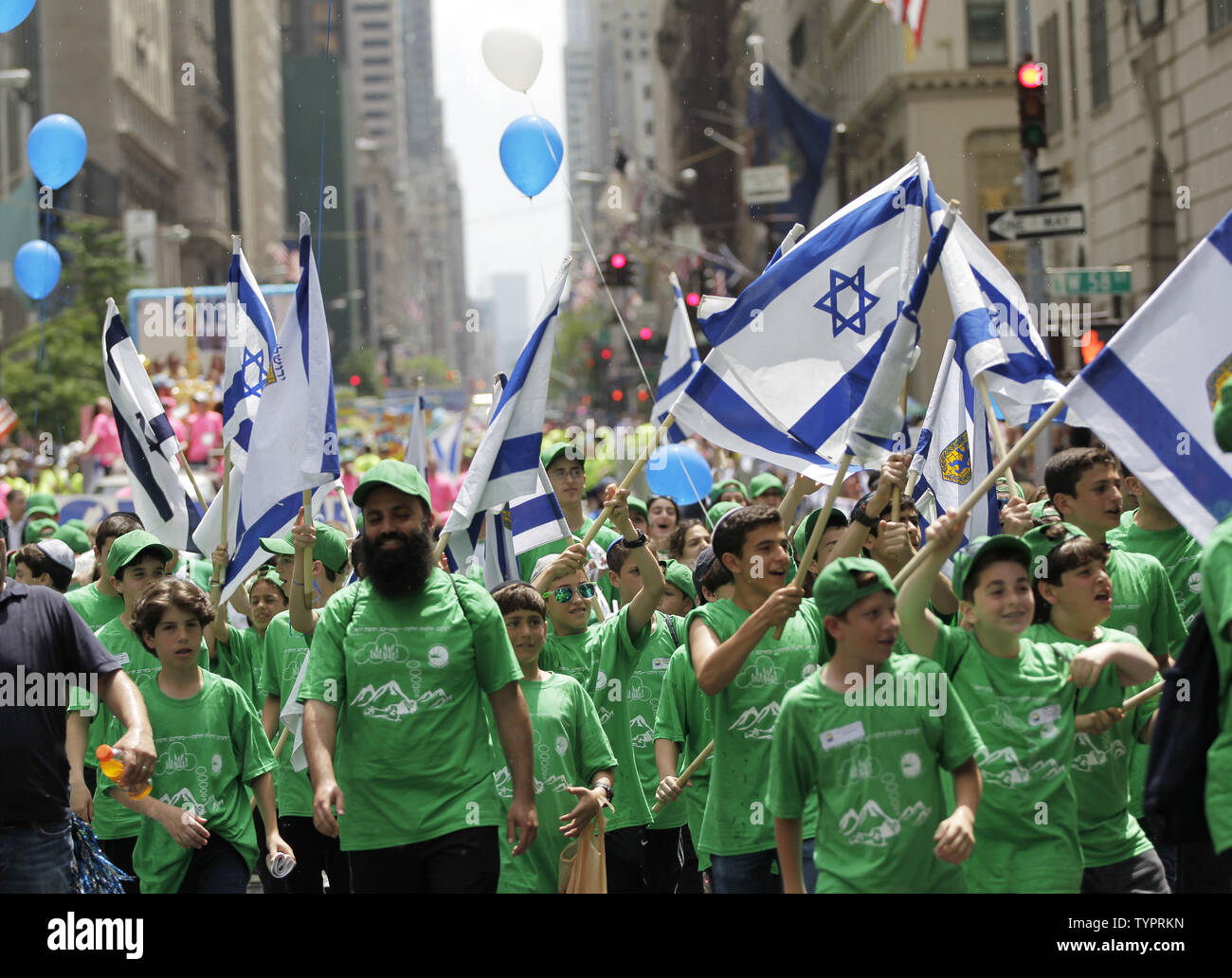 Participants march up Fifth Avenue carrying Israeli Flags and balloons ...