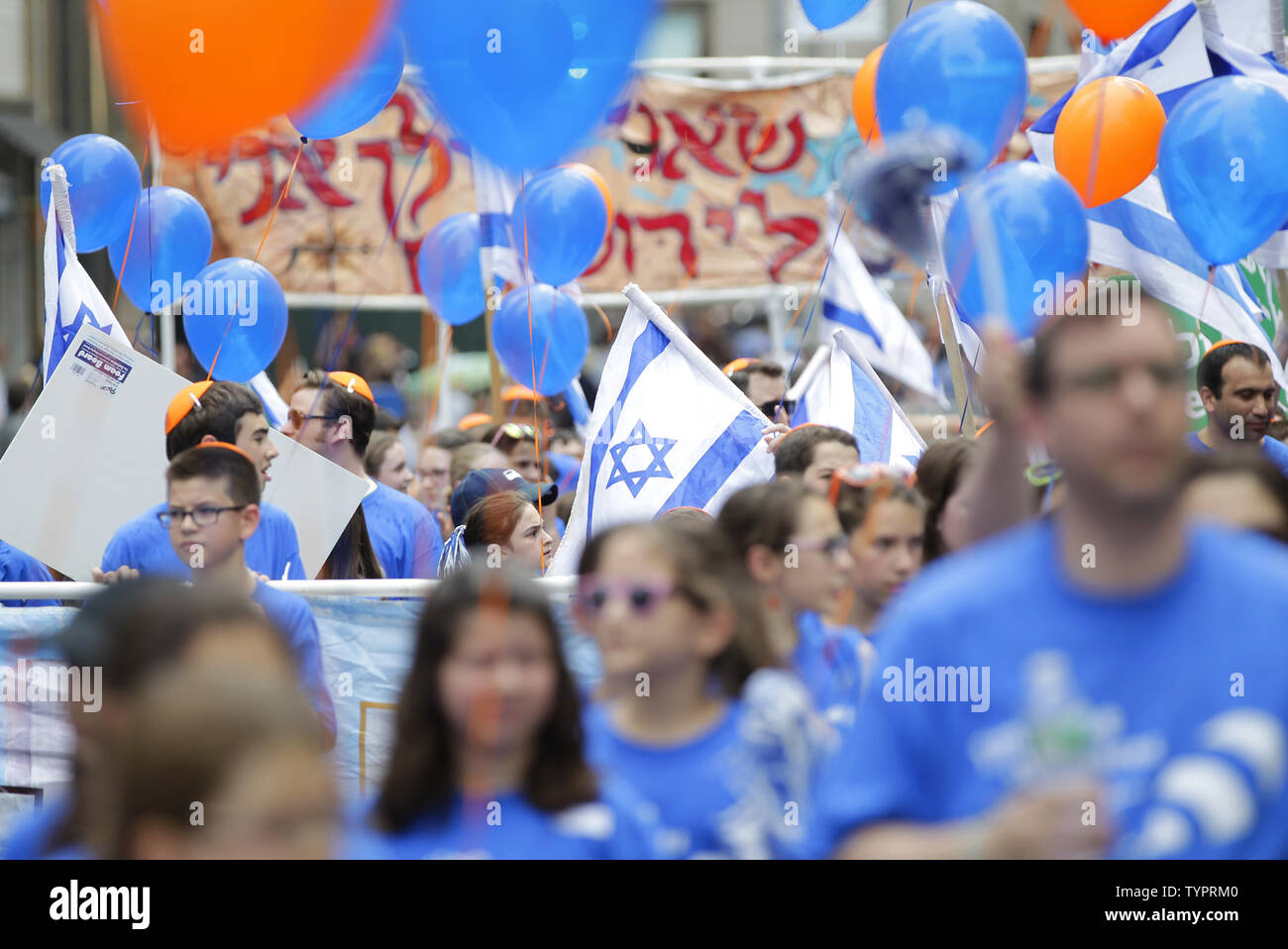 Participants march up Fifth Avenue carrying Israeli Flags and balloons ...